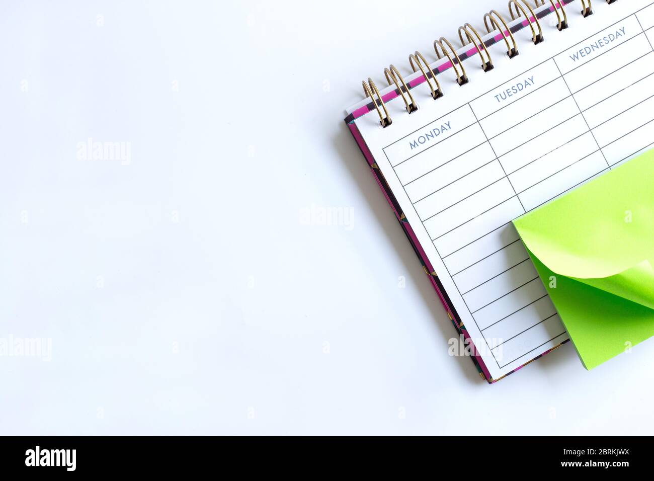 Weekly planner organiser with green sticky note on white background ...