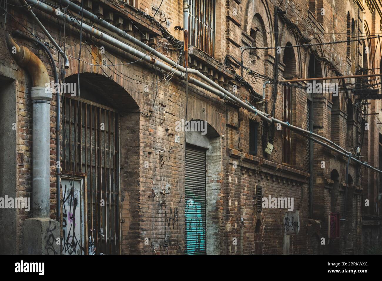 Weathered facade of an abandoned old textile factory with doors ...