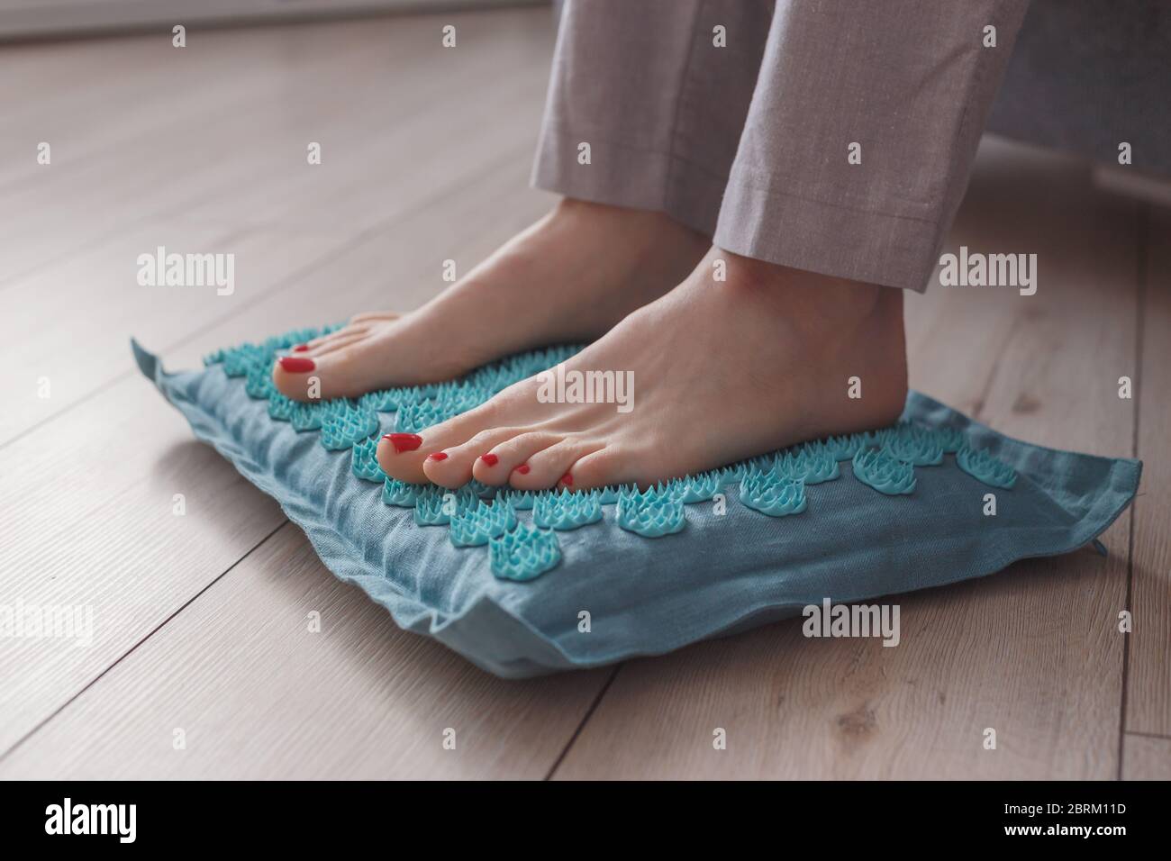 Female feet standing on acupressure mat. Self acupuncture massage ...
