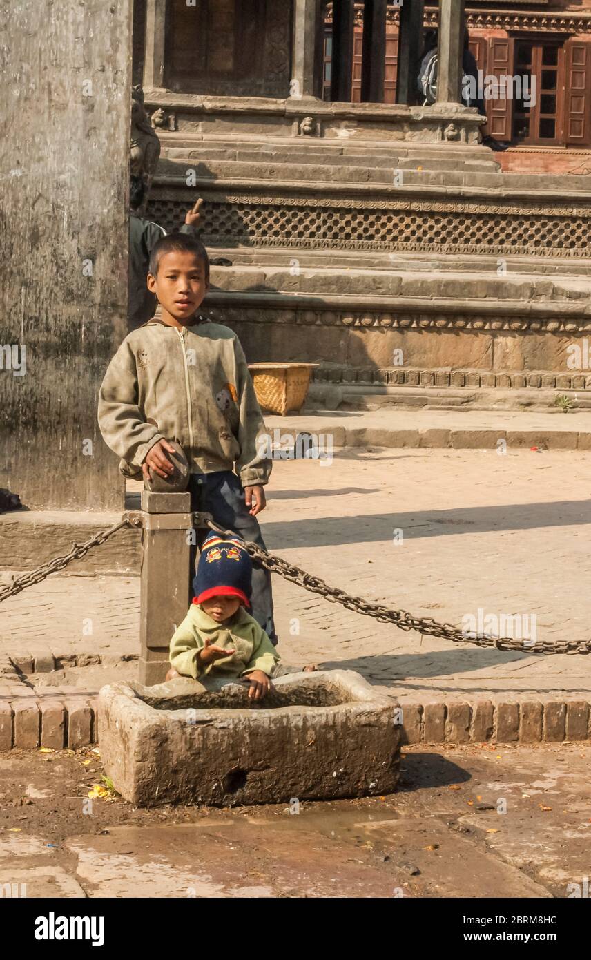 Nepal. Kathmandu. A young boy with his brother in the medieval Durbar ...