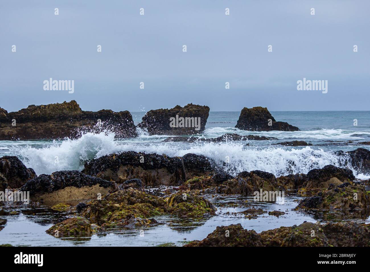 Tidal pools with ocean waves crashing over rocks into pools Stock Photo ...