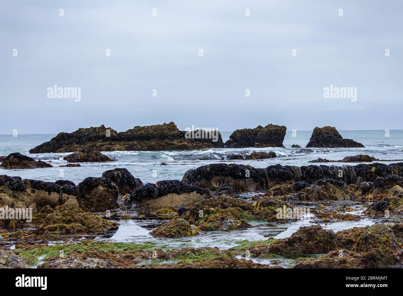 Tidal pools with ocean waves crashing over rocks into pools Stock Photo ...