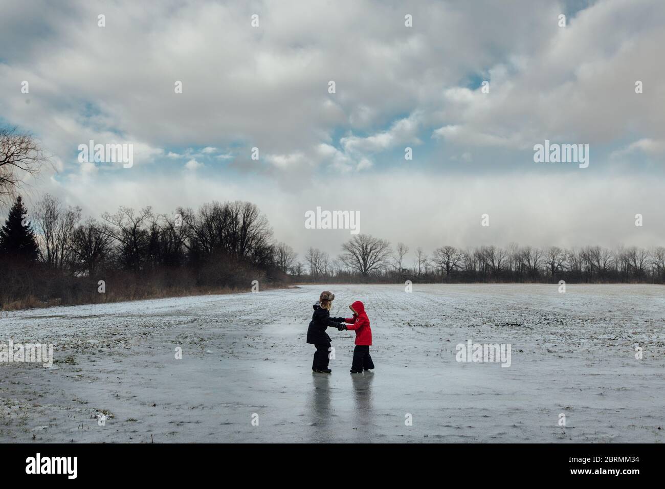 two sisters playing on a frozen farm field in winter Stock Photo - Alamy