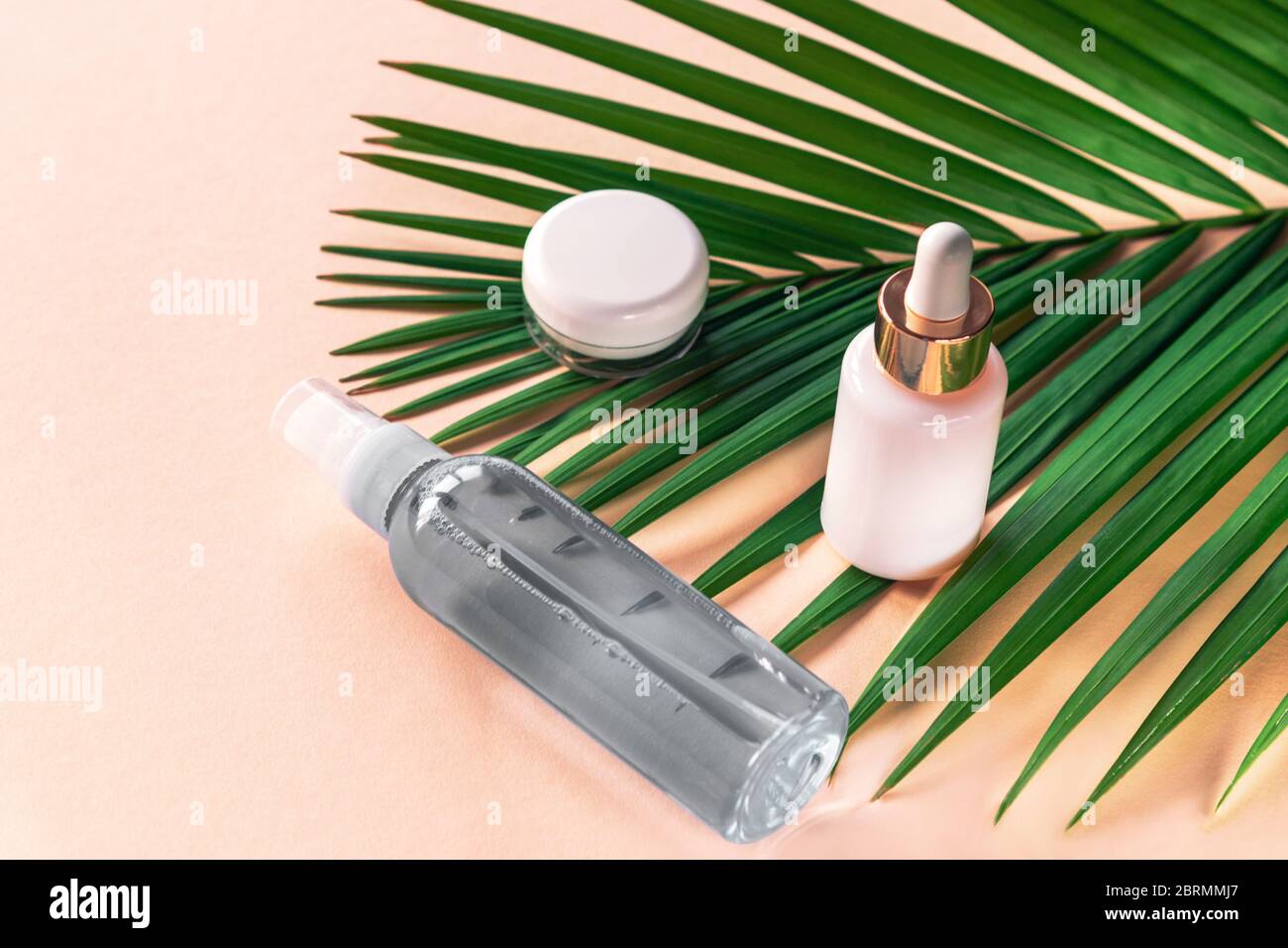 Facial and body care cosmetics bottles on yellow background. Serum ...