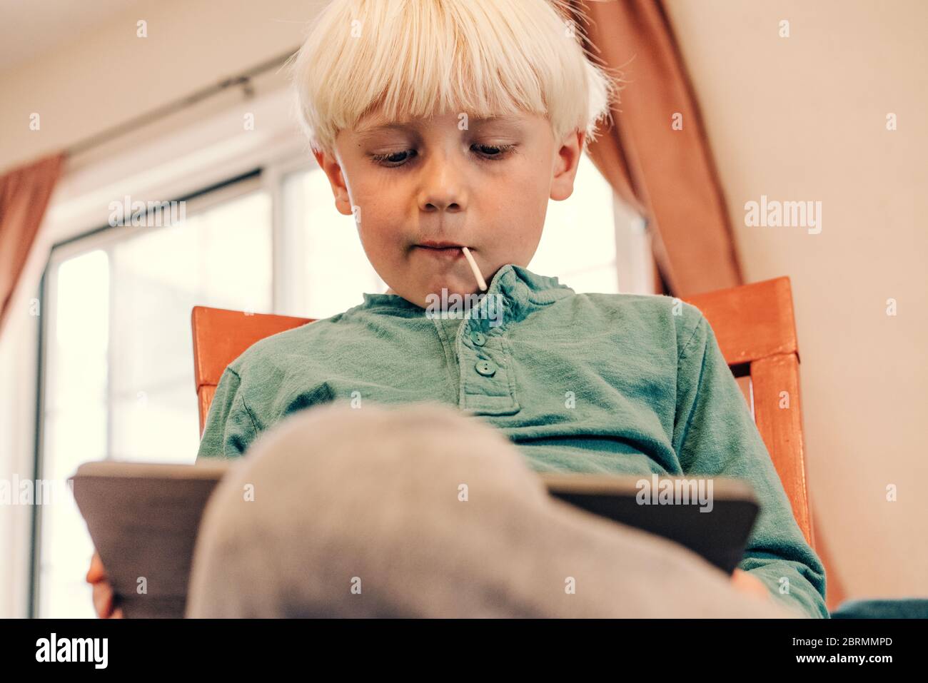 Young boy doing school work on tablet Stock Photo - Alamy