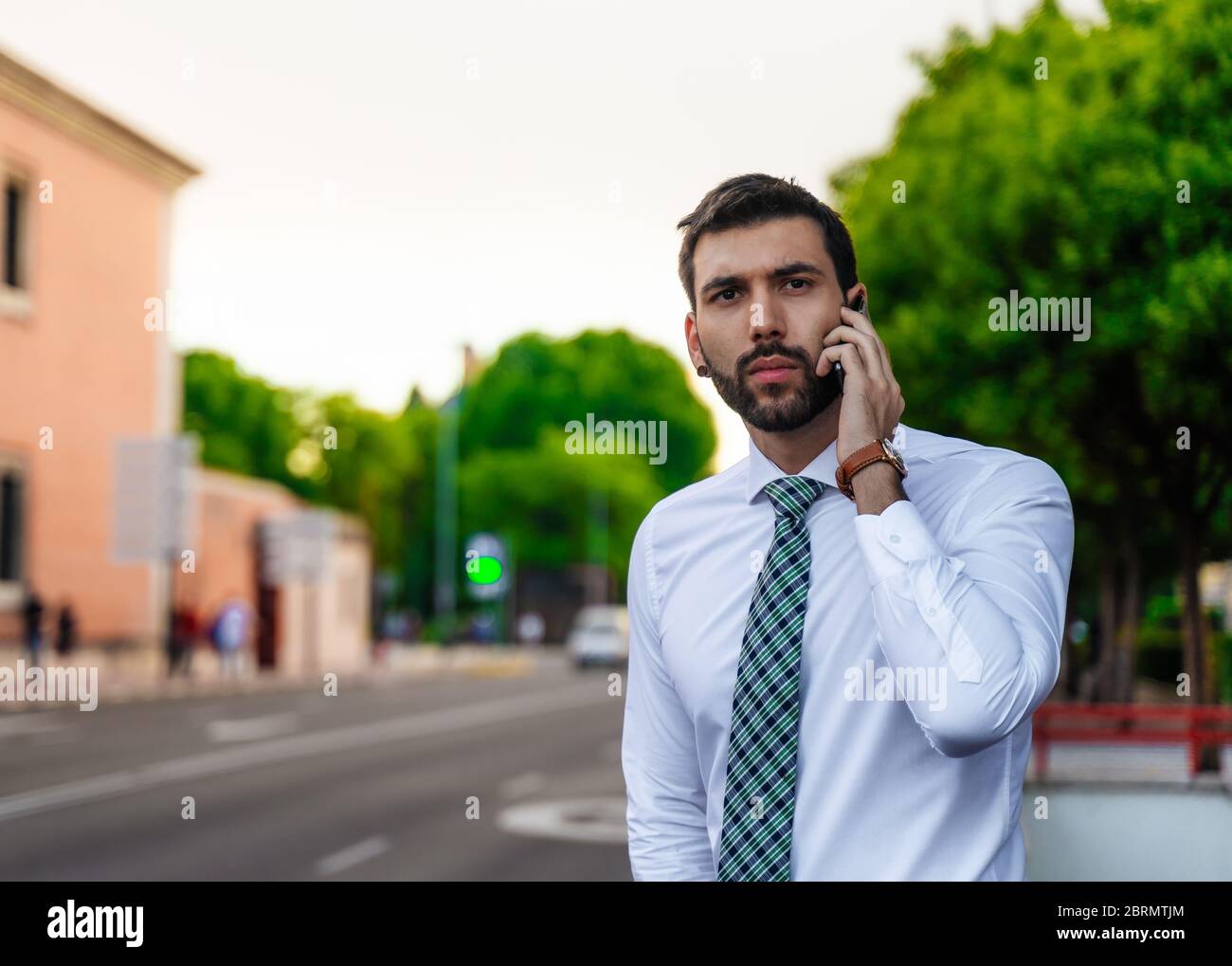 Young business man with white shirt and tie in outdoor city making a ...