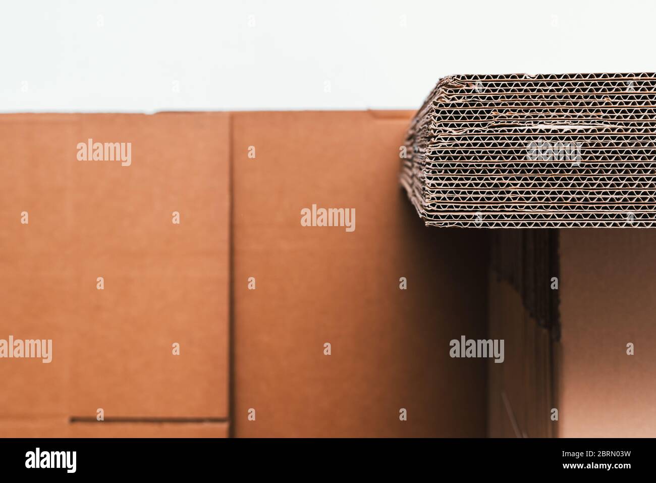 Cardboards stacked on a white wall ready to form boxes to transport ...