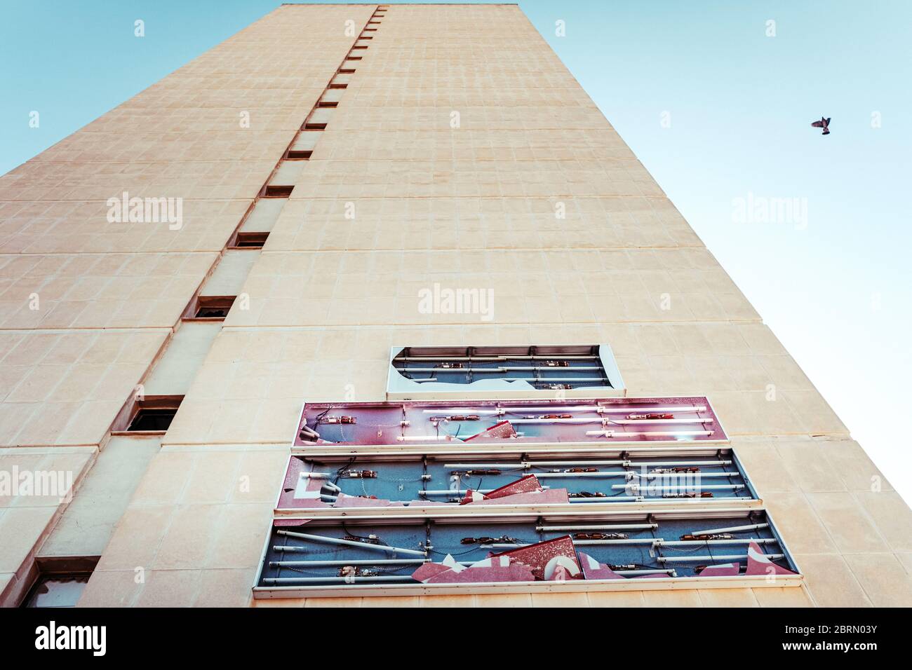 Clean facade of an abandoned hotel building with broken windows during ...