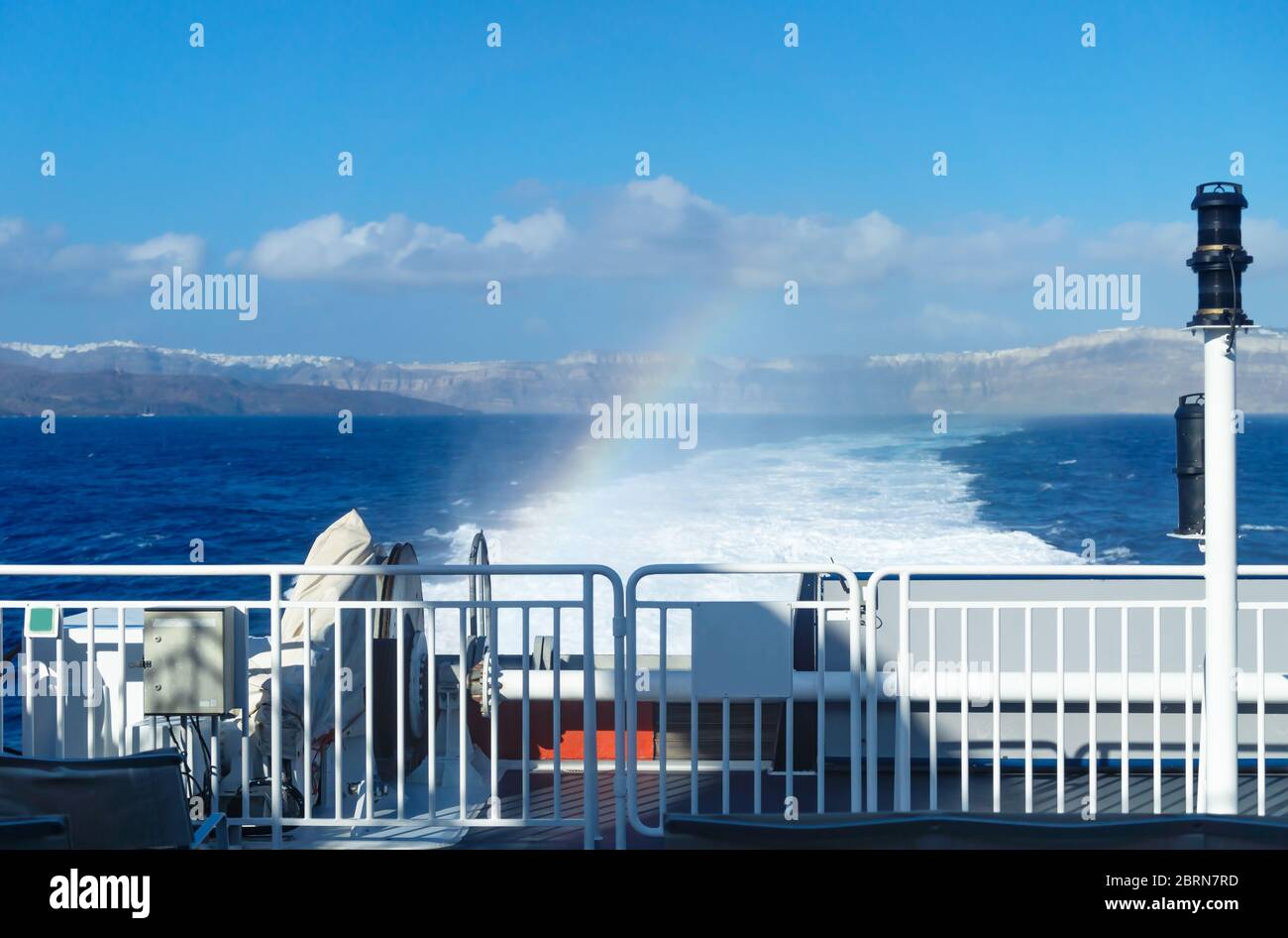 Back of ferry boat with rainbow from splashing water with blurred view ...