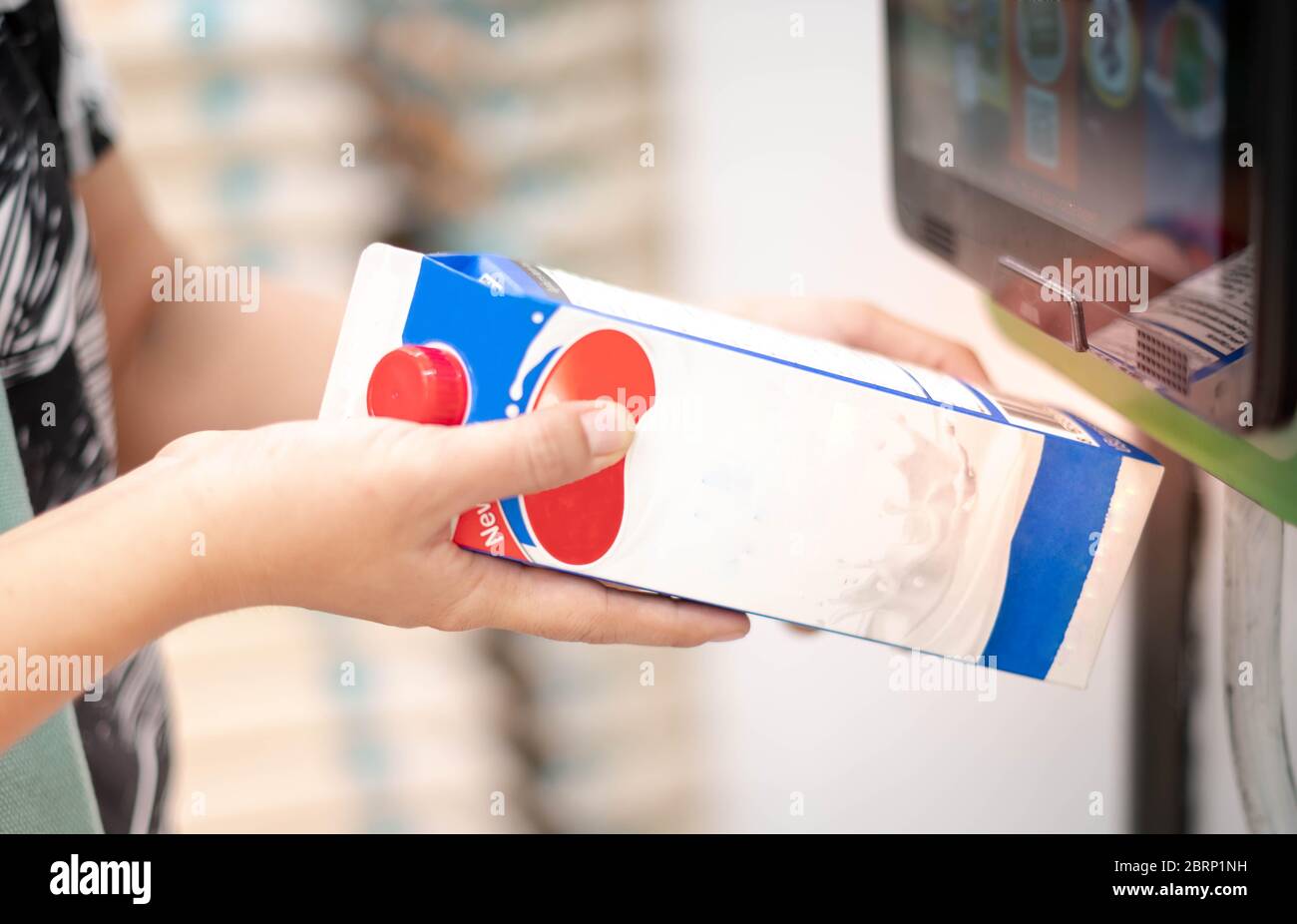Close-up of female hand holding goods scanning at checkout at the ...