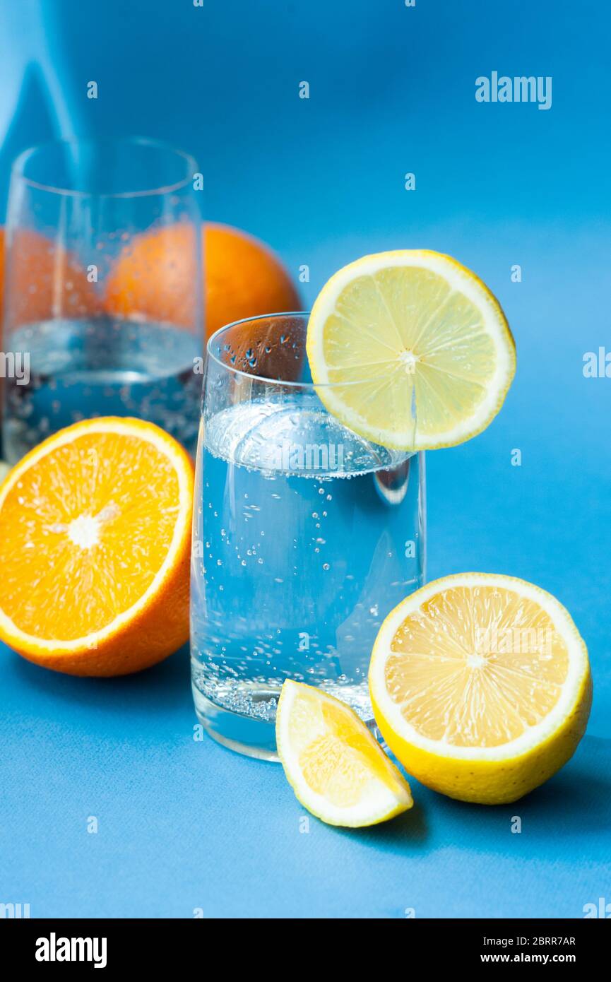 two glasses of sparkling clear water with bubbles and lemon and ripe ...