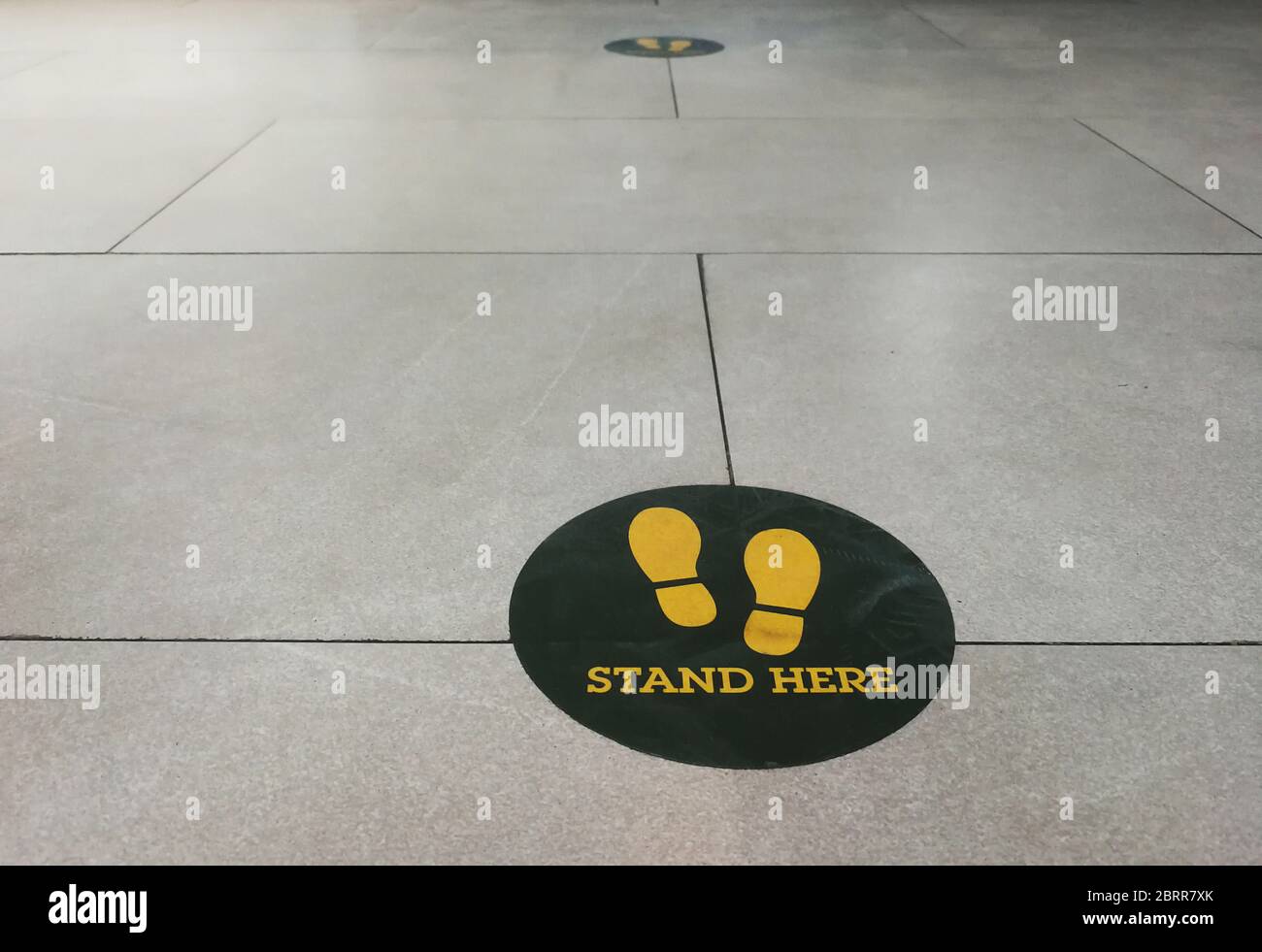 Stand here foot sign or symbol on the floor Stock Photo - Alamy