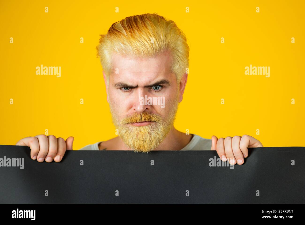 Man holding empty sheet of a paper. Man showing blank paper. Copy space ...