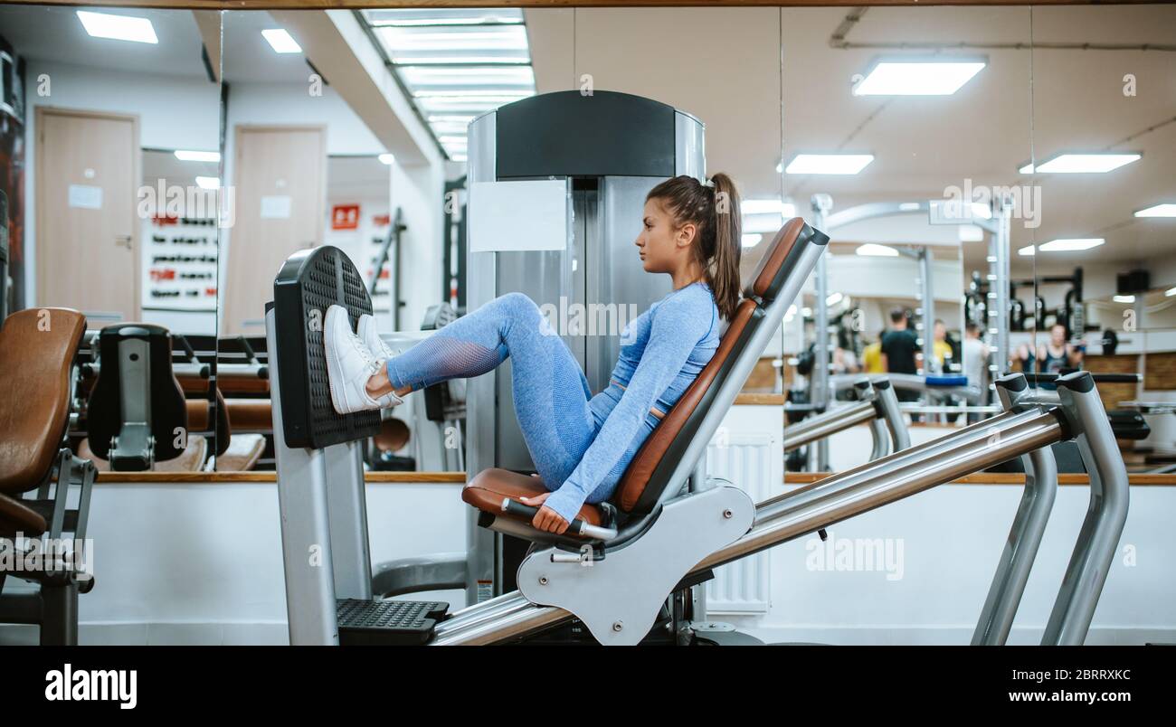 An attractive young caucasian girl in blue sports equipment on a leg ...