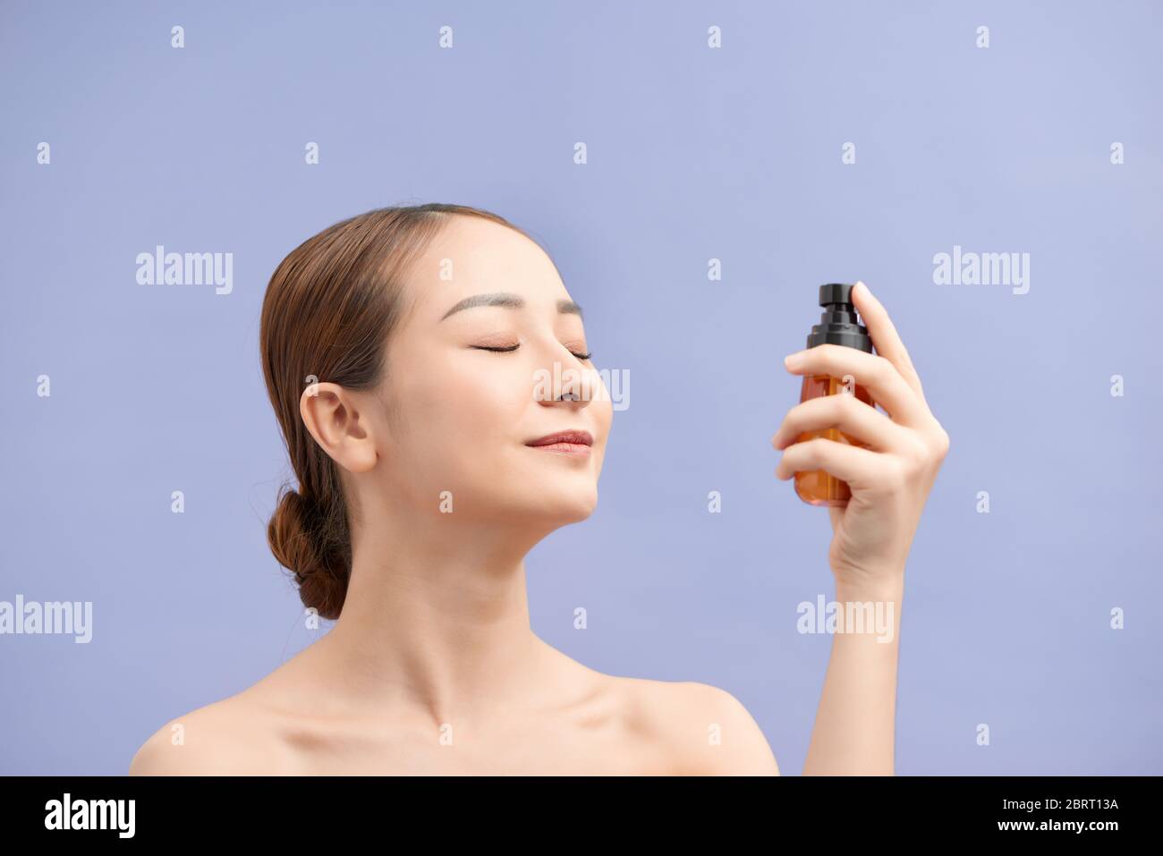 Beautiful asian woman holding spray water bottle isolated white ...