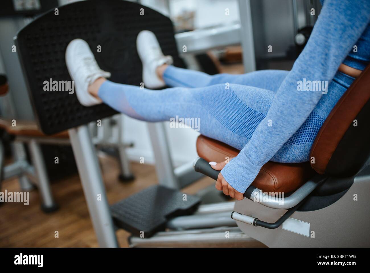 An attractive young caucasian girl in blue sports equipment on a leg ...