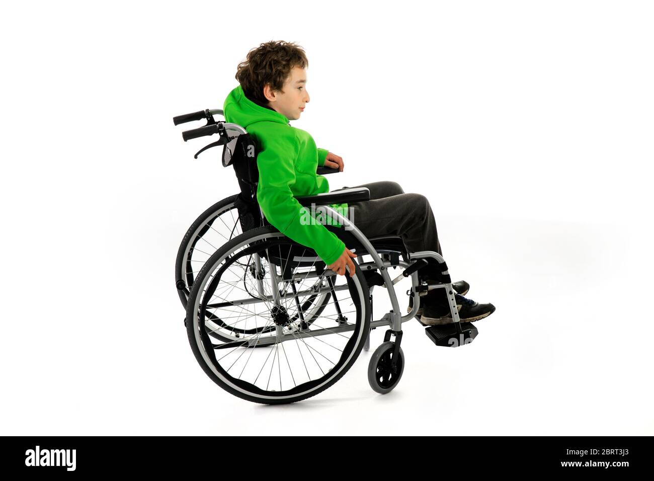 Little boy in wheelchair on white background , boy is sitting in a ...