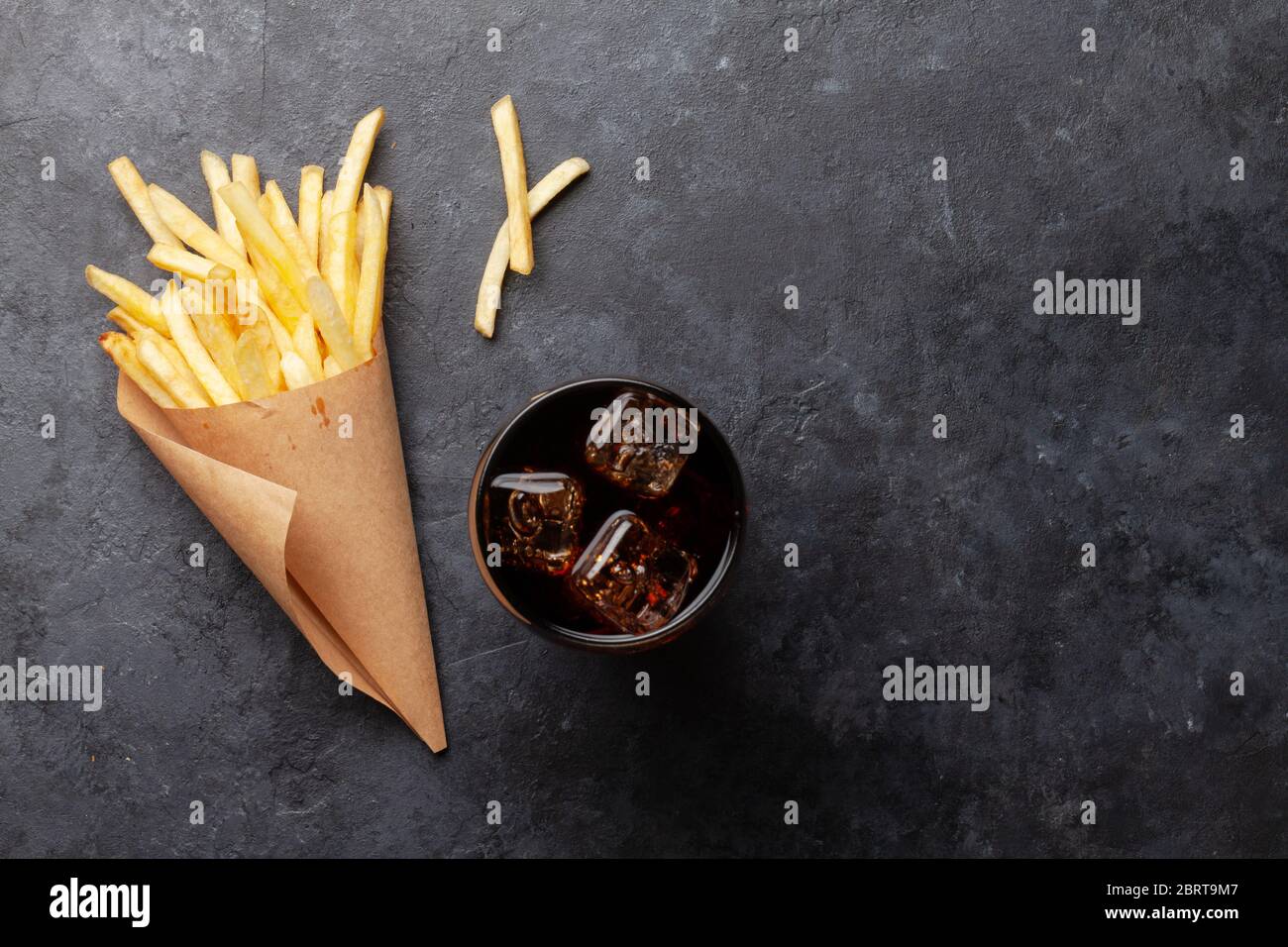 Glass of cola drink with ice and potato fries chips. Fast food take ...