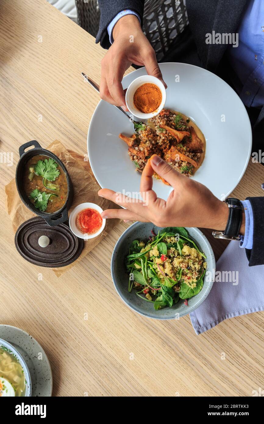Man is eating in a restaurant and enjoying delicious food top view ...