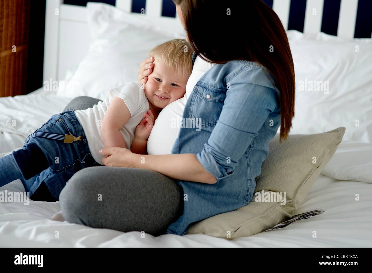 Pregnant woman embracing her little child Stock Photo - Alamy