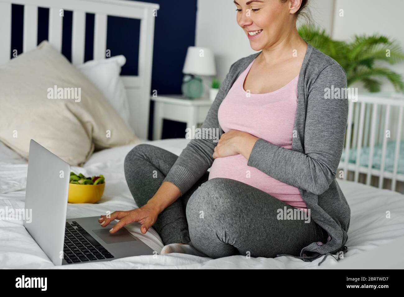 Cheerful pregnant woman using computer Stock Photo - Alamy