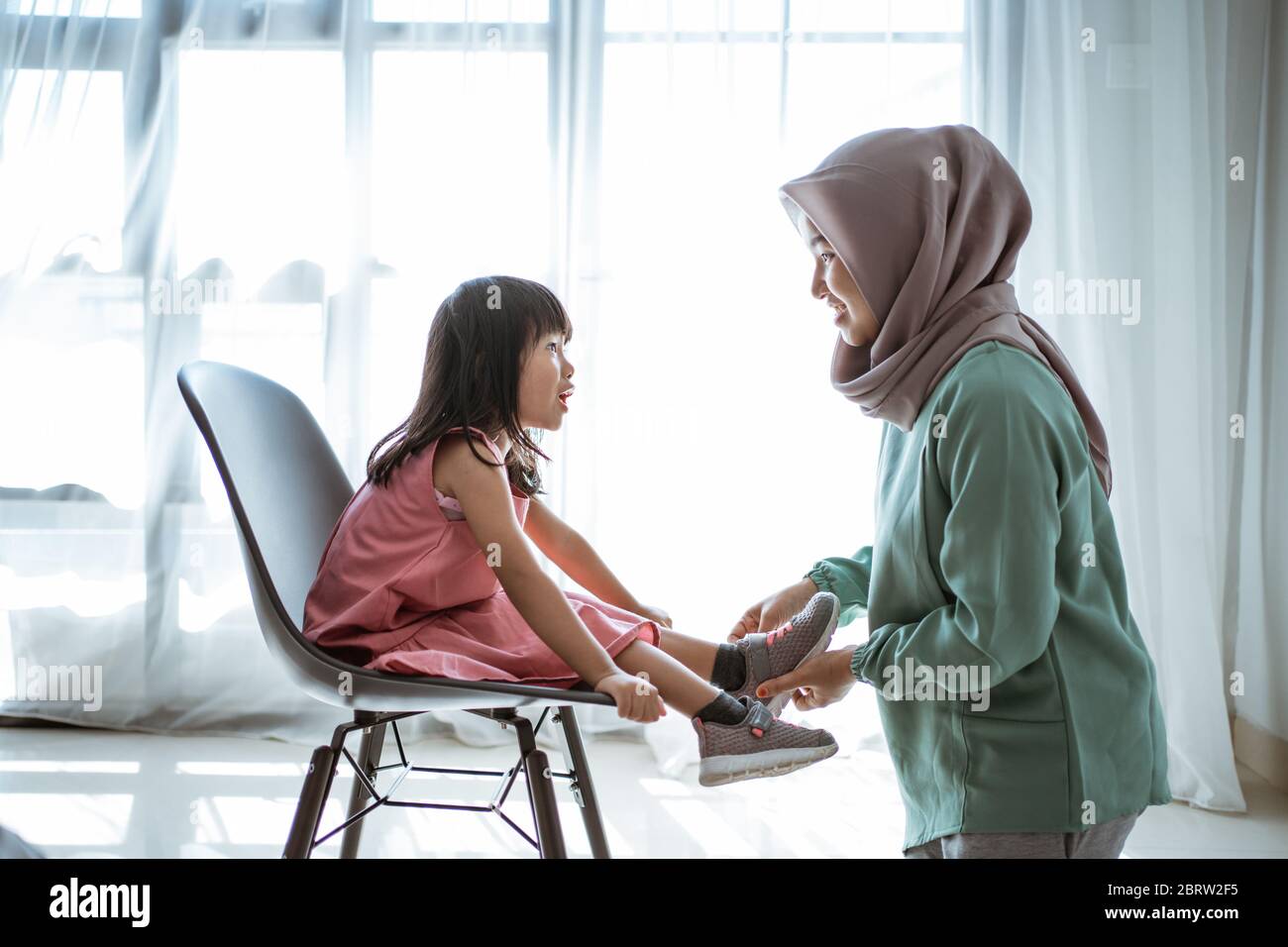 muslim mother help her daughter preparing school. islamic school ...