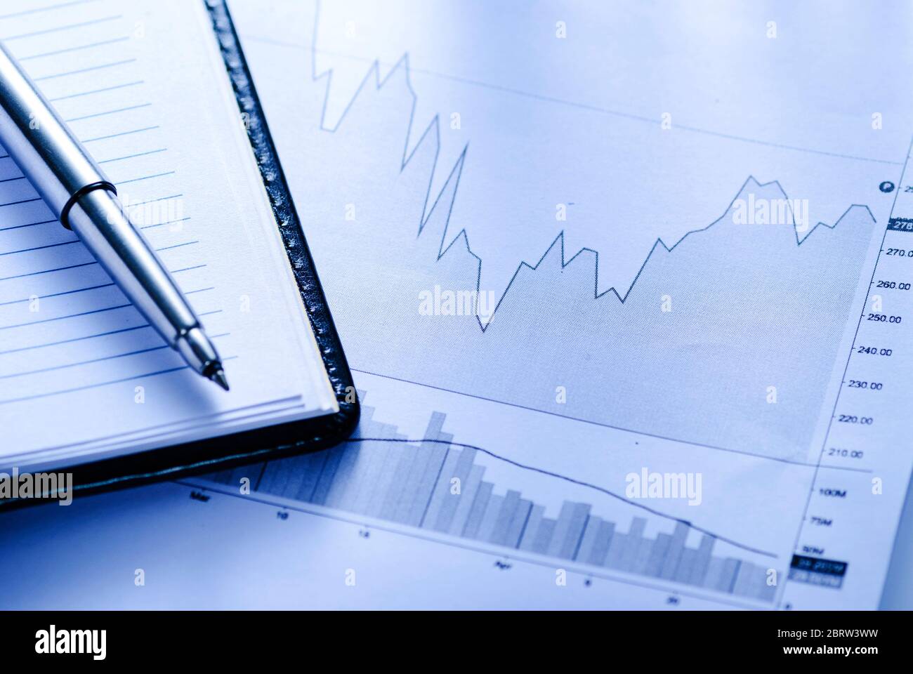 Open journal with business graphs and pen in a business accounting or ...