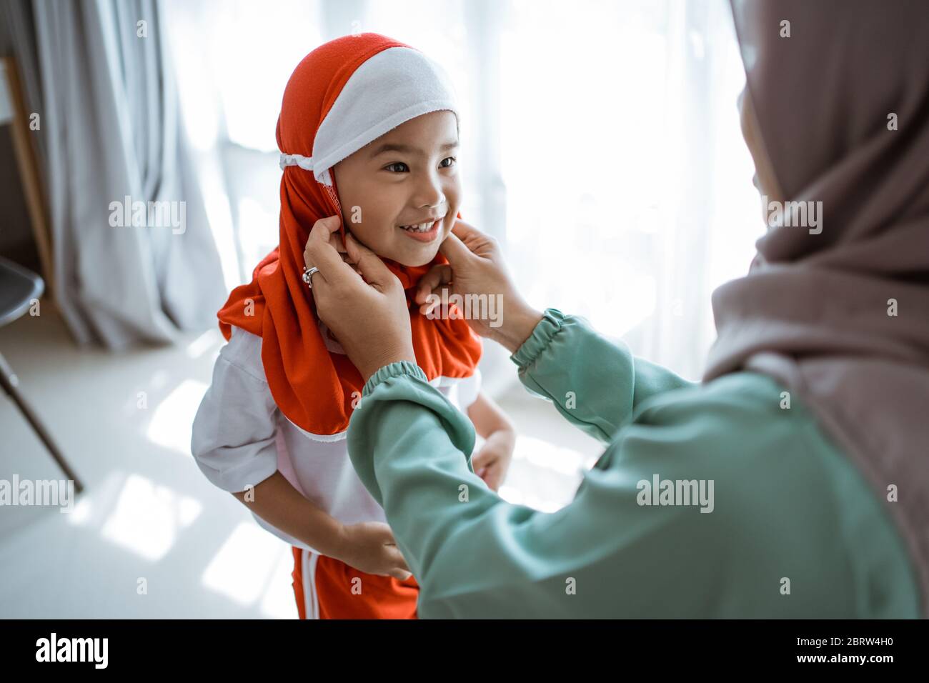 muslim mother help her daughter preparing school. islamic school ...