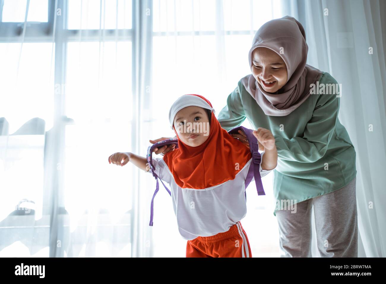 muslim mother help her daughter preparing school. islamic school ...