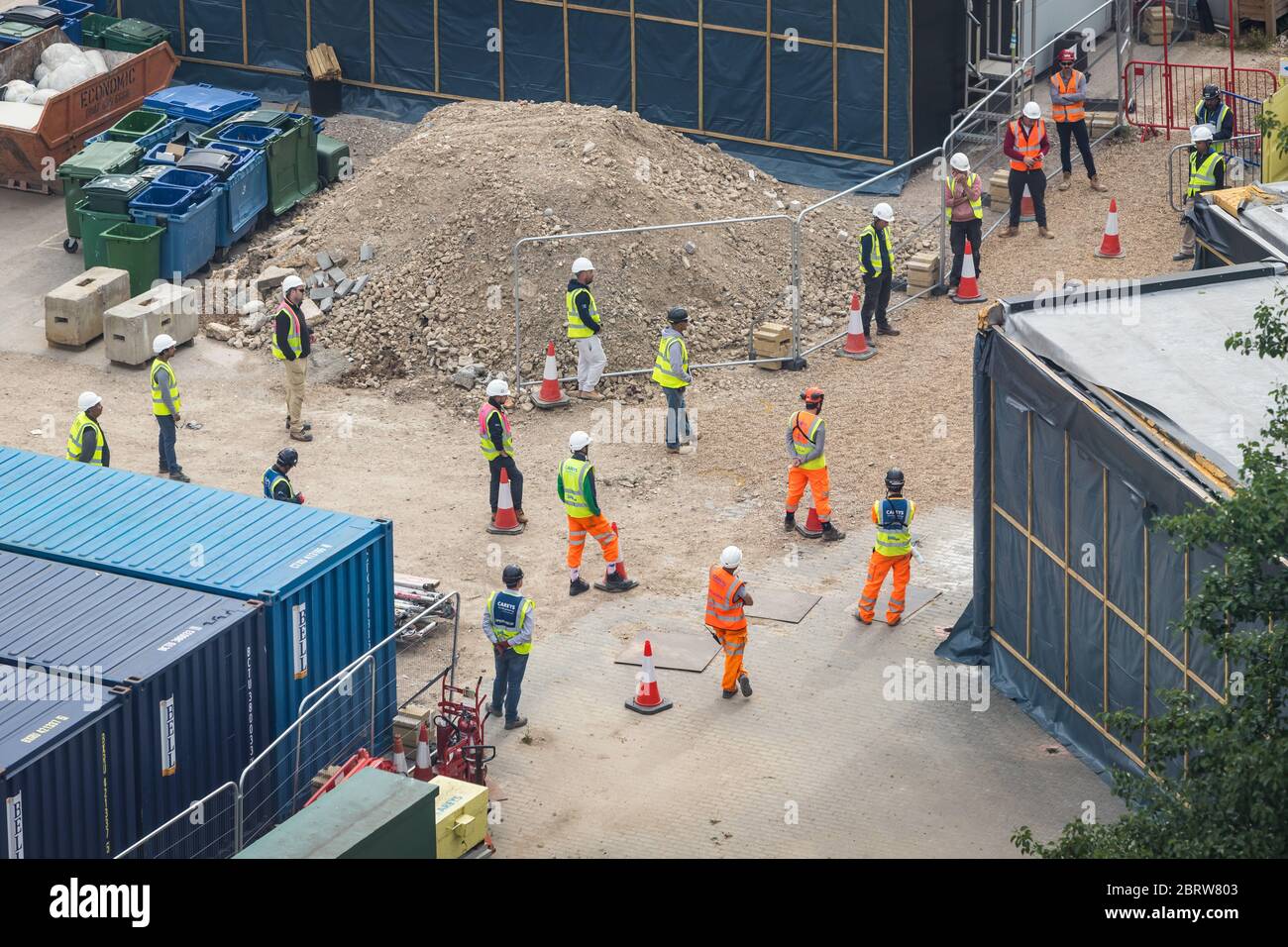 Construction workers observing social distancing during a team meeting ...