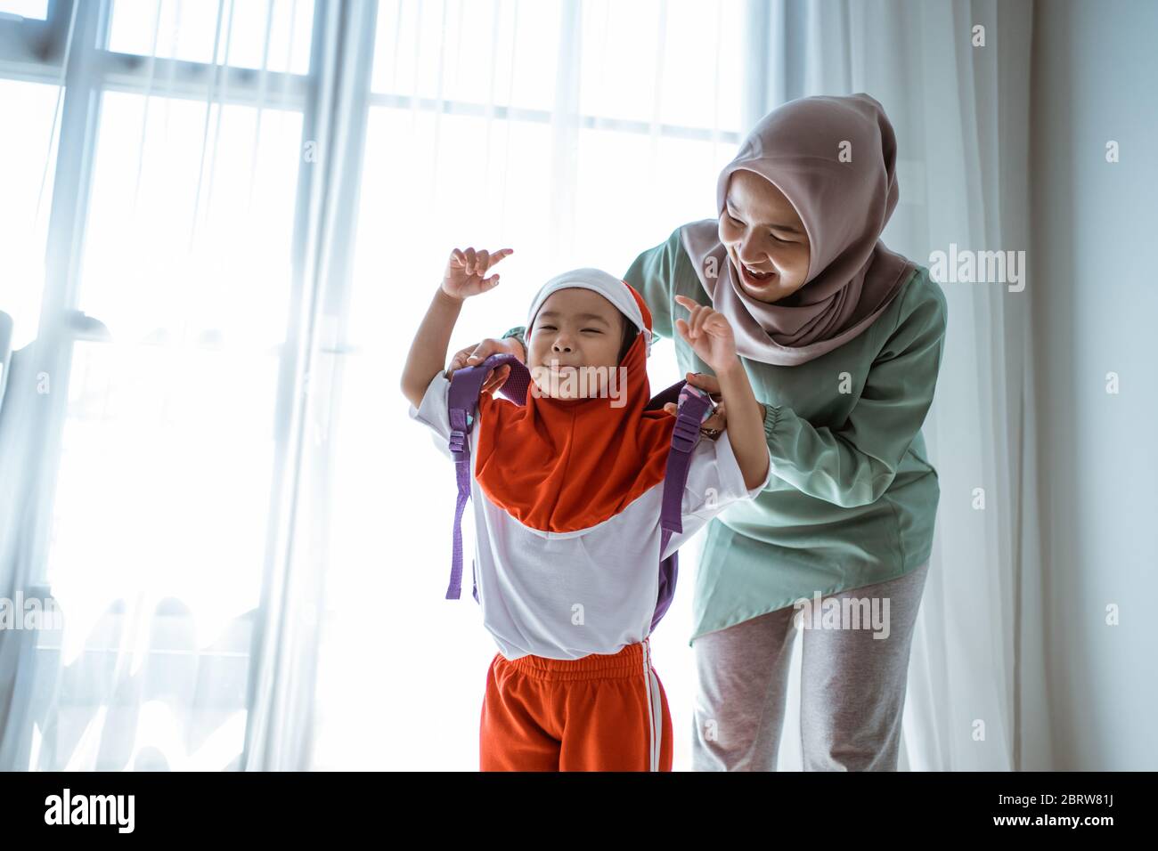 muslim mother help her daughter preparing school. islamic school ...