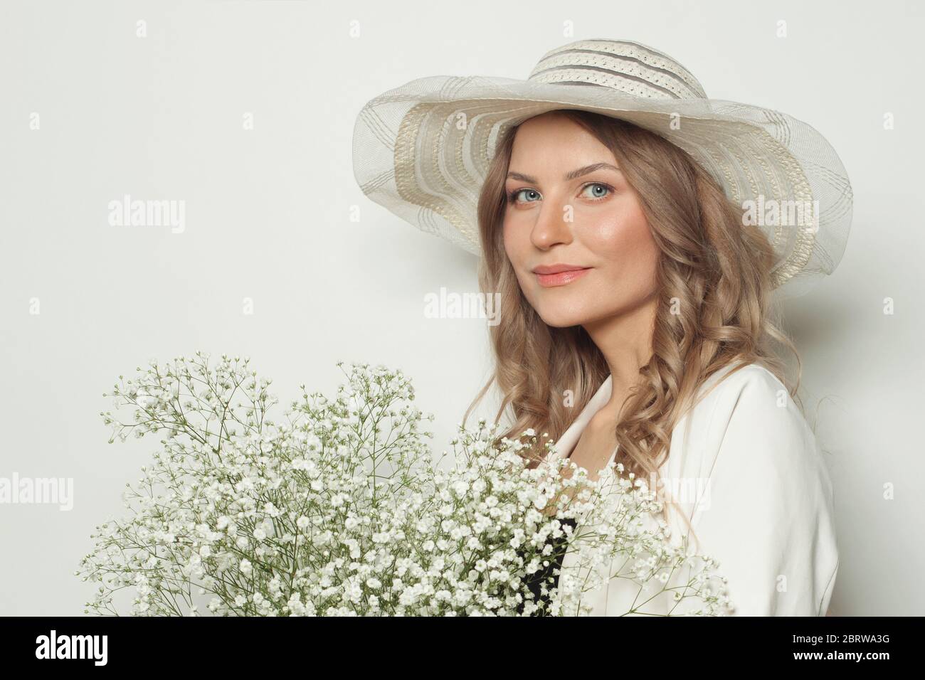 Beautiful model woman in white hat on white background Stock Photo - Alamy