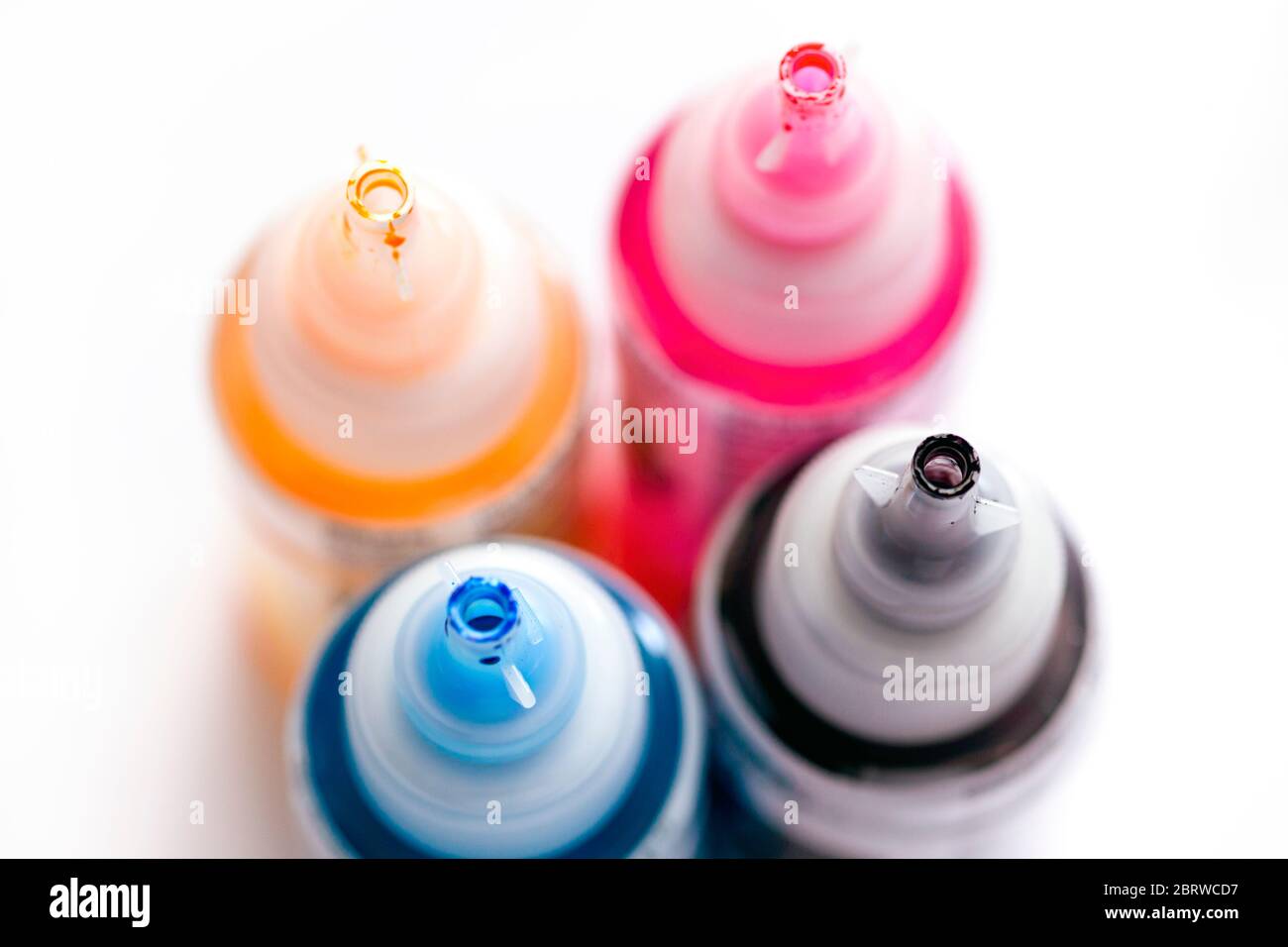 Four open printer bottles with CMYK colour ink. White background ...