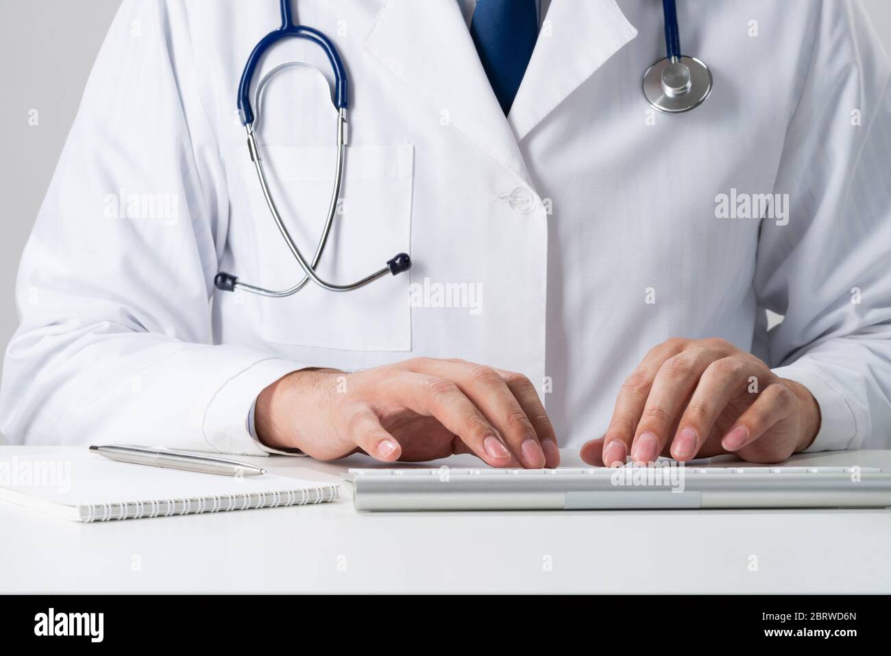 Male therapist typing at computer keyboard Stock Photo - Alamy
