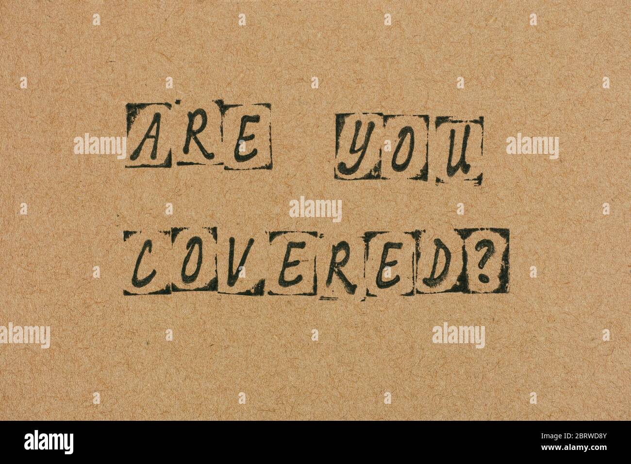 Cardboard with words Are You Covered? made by black alphabet stamps ...