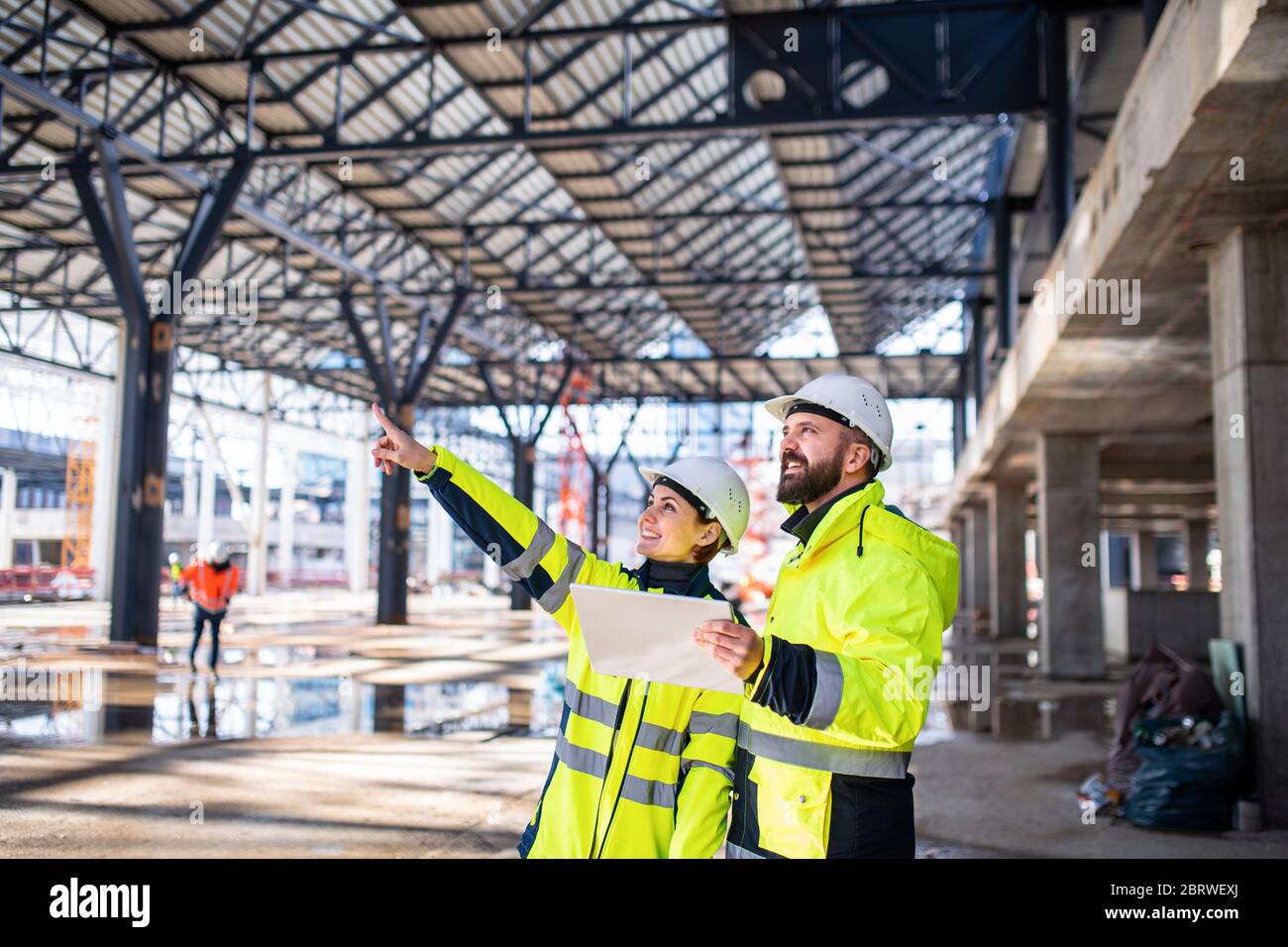 Engineers standing outdoors on construction site, holding tablet Stock ...