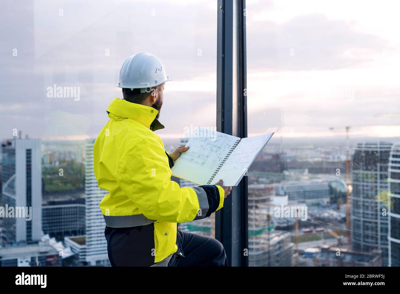 Man engineer standing on construction site, holding blueprints Stock ...