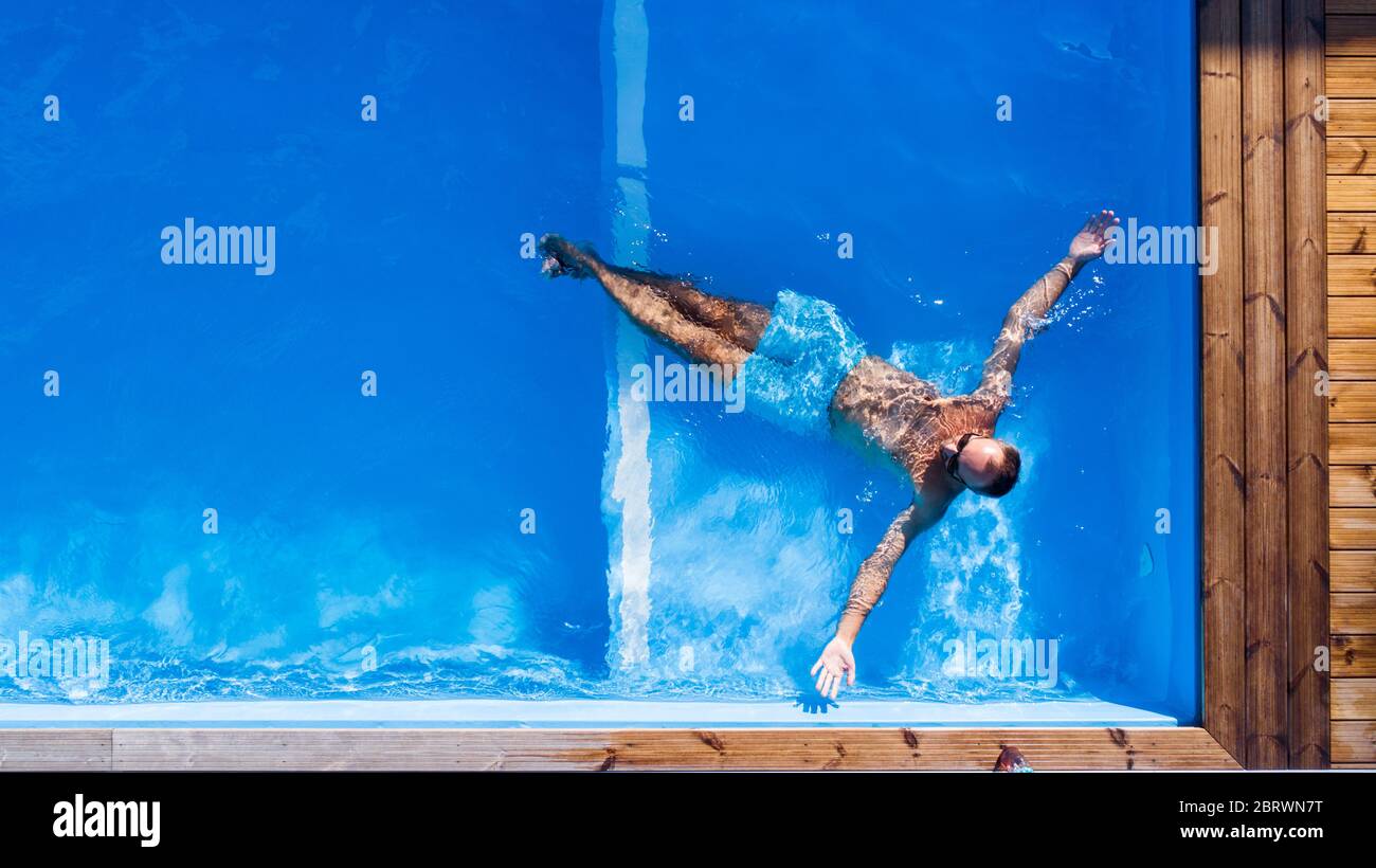 Top view of man lying in water in swimming pool outdoors Stock Photo ...