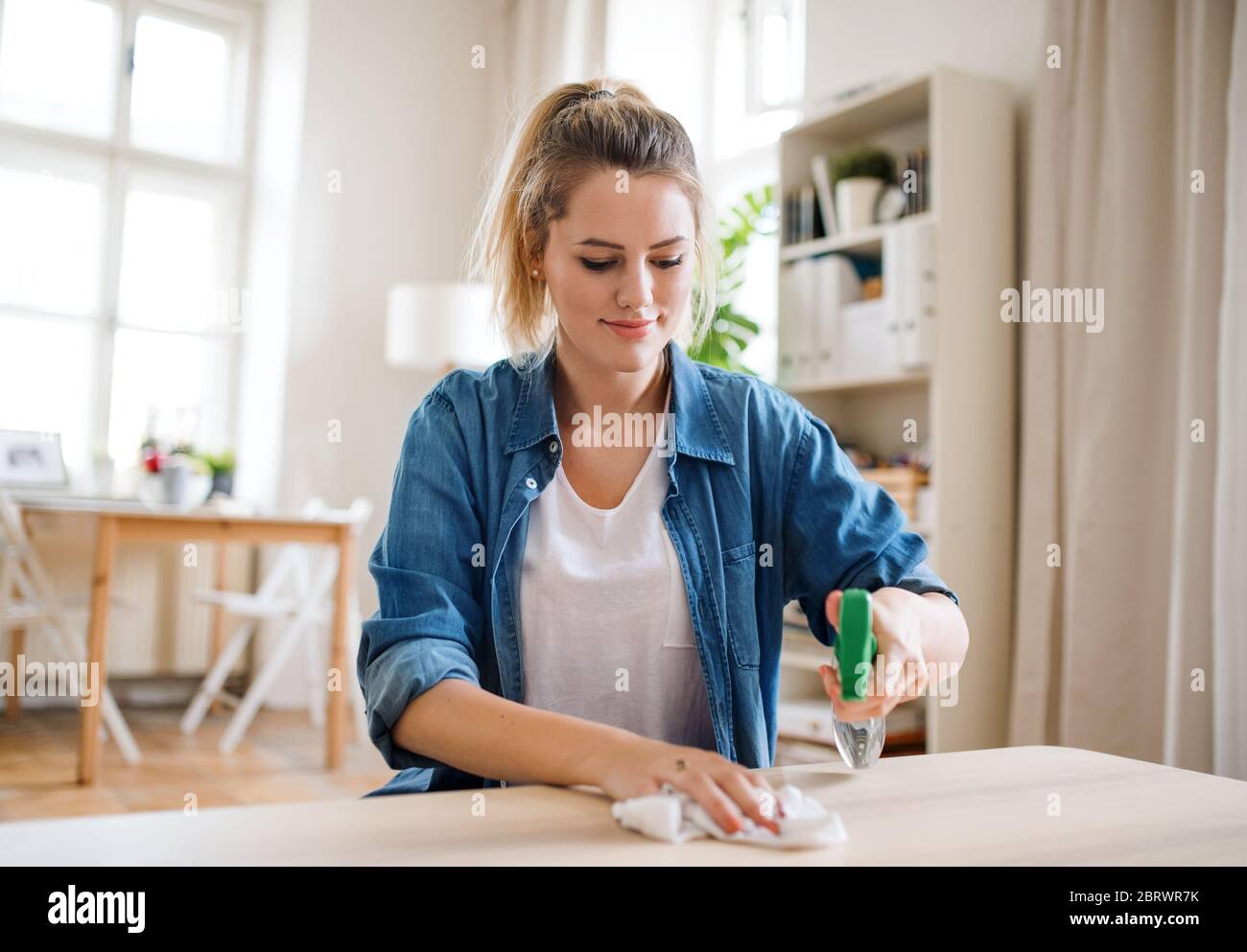 Young woman indoors at home, cleaning table Stock Photo - Alamy