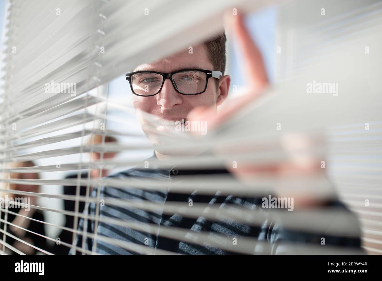 young pensive businessman looking out the window in office Stock Photo ...