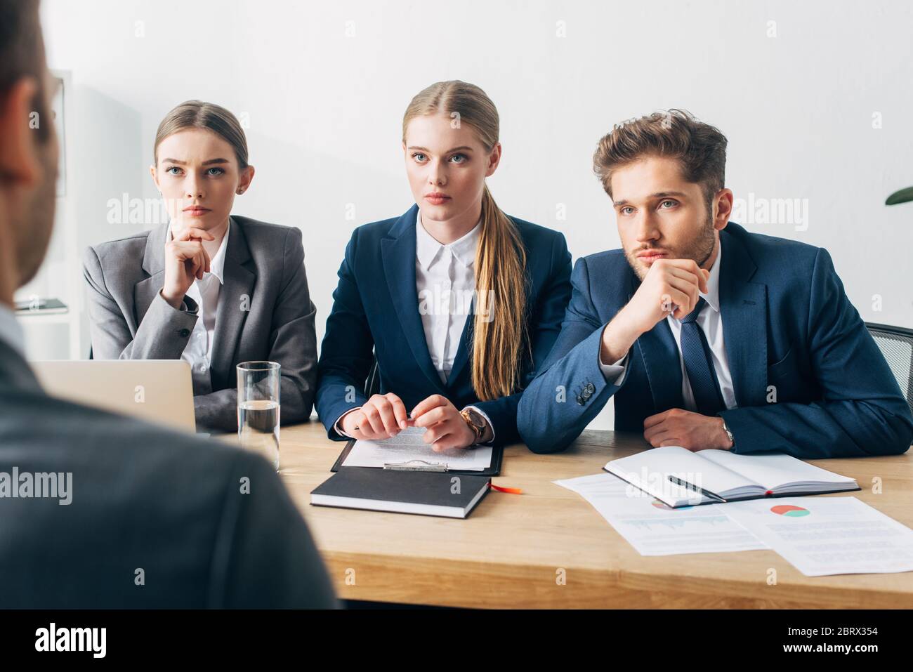 Selective focus of recruiters looking at employee during job interview ...