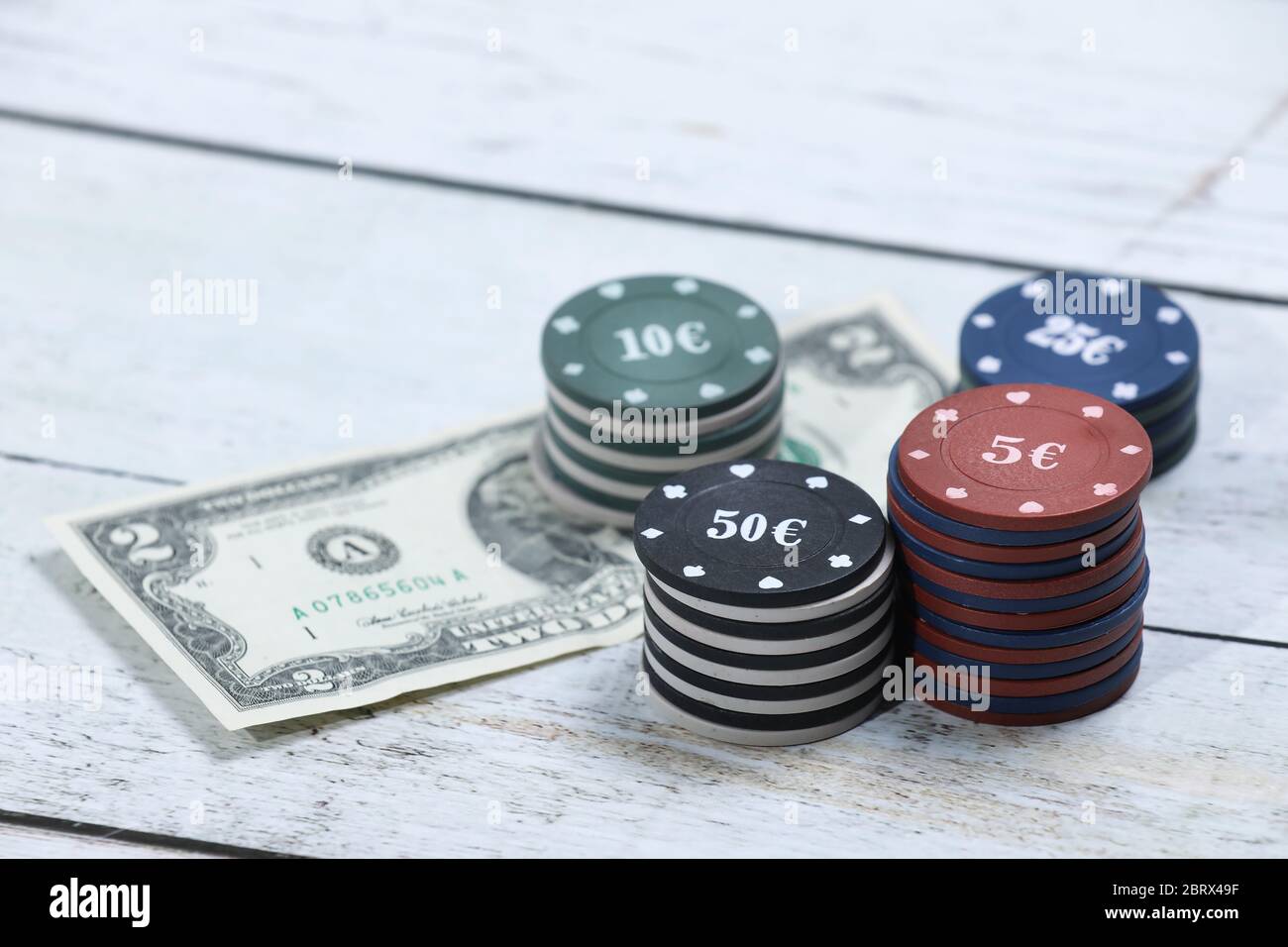 Poker playing chips in focus in front on a wooden table . Online ...