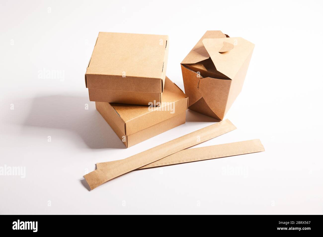 chopsticks in paper packaging near takeaway boxes with chinese food on ...