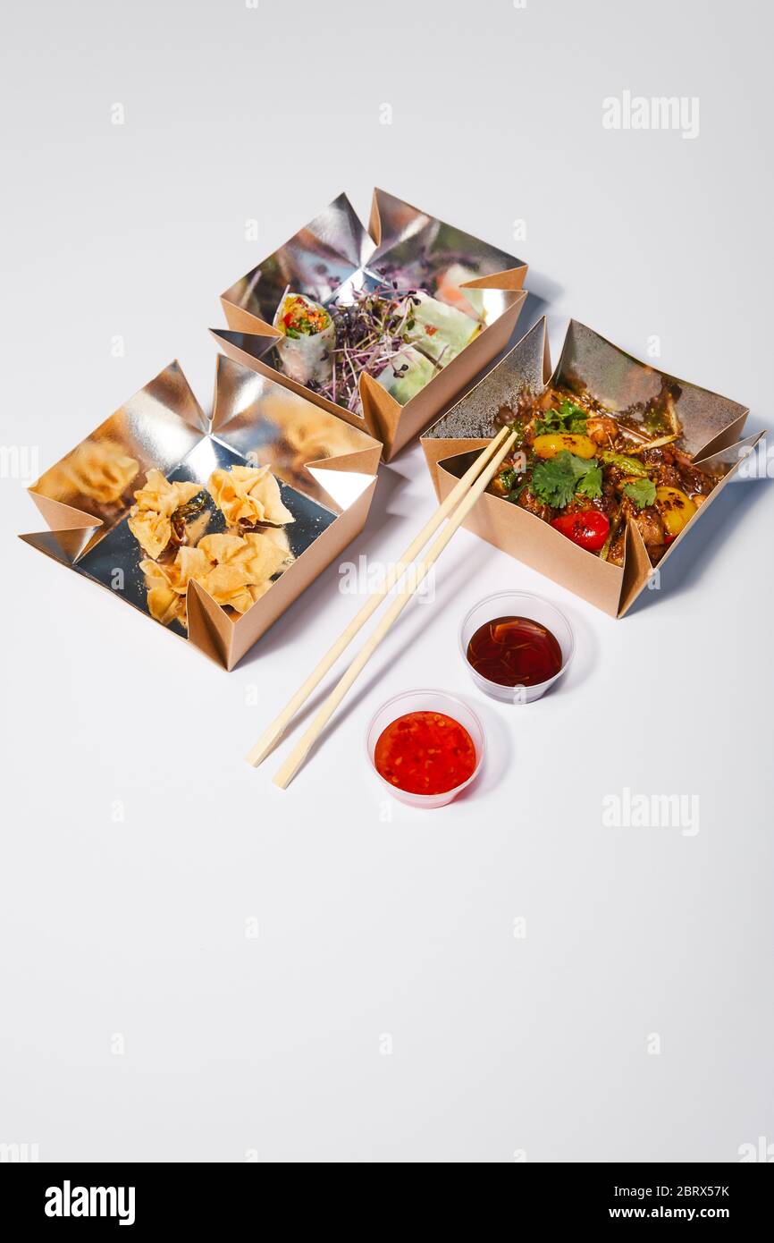 takeaway boxes with tasty and prepared chinese food near chopsticks and ...