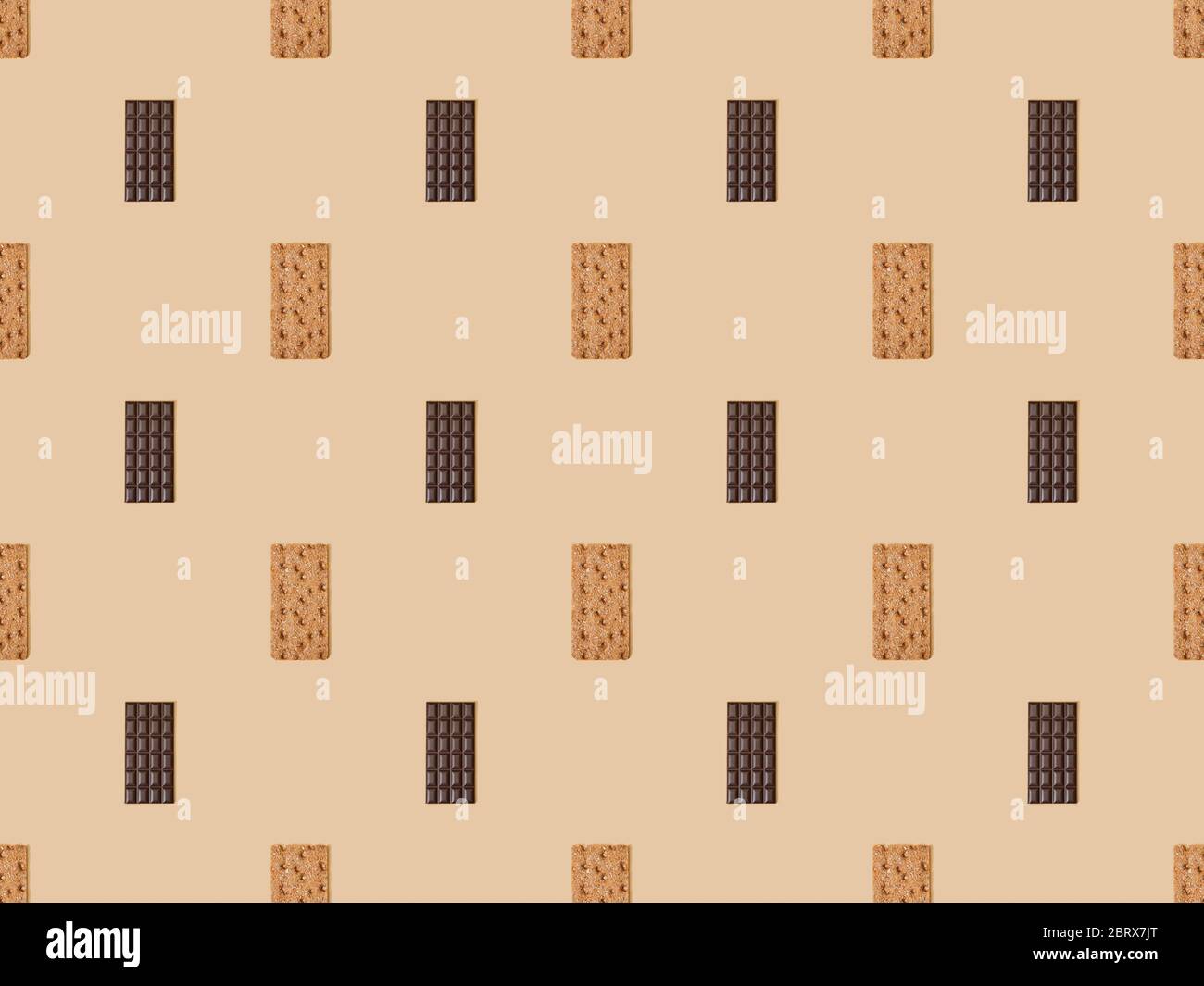 top view of sweet dark chocolate bars and crispbread on beige ...