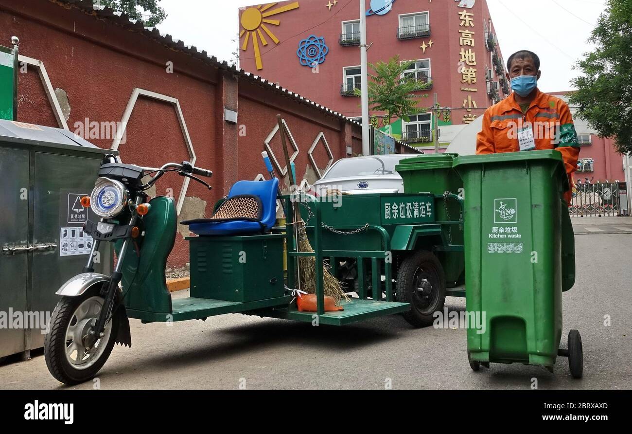 Beijing, China. 22nd May, 2020. A worker transfers garbage sorting bins ...