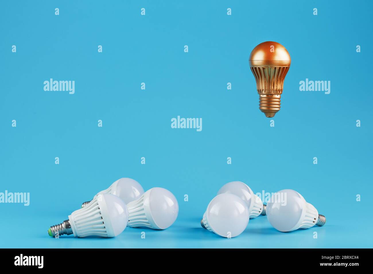 A prominent gold light bulb levitates above an environment of white led ...