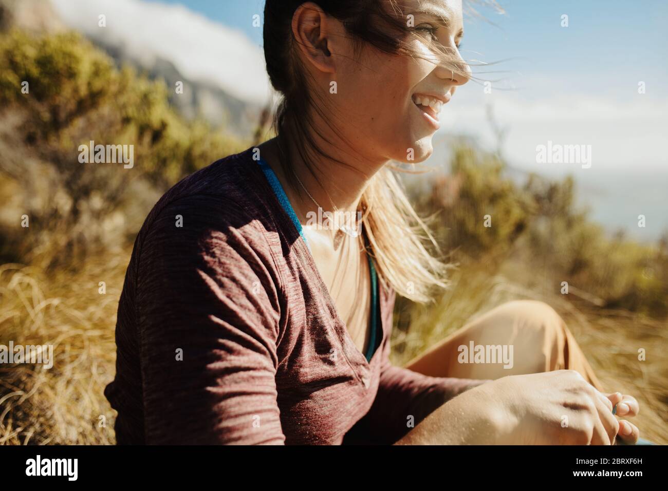 Woman hiker sitting on cliff and looking away at the view. Female ...