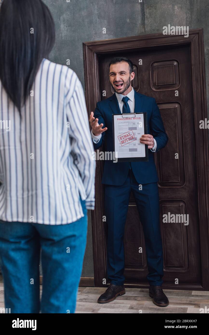 Angry collector with documents with foreclosure and final notice ...