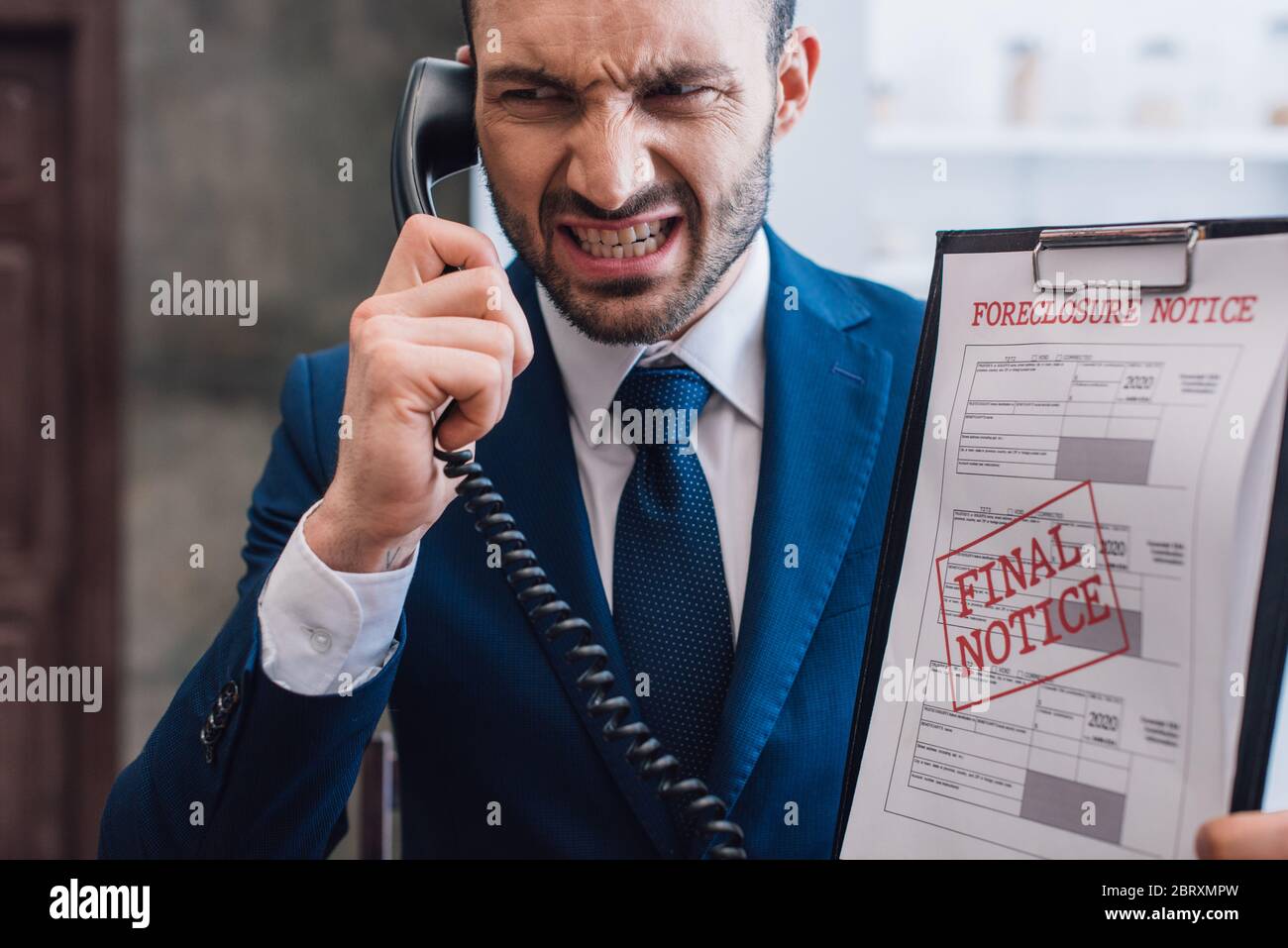 Angry collector with handset and documents with foreclosure and final ...